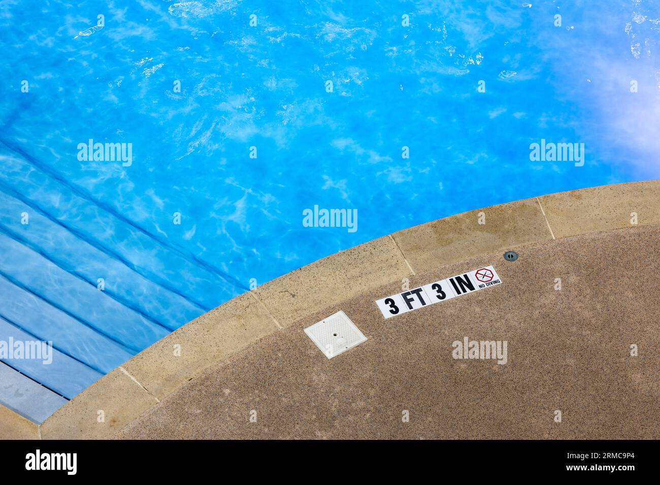 Edge of swimming pool with No Diving warning sign and 3 ft depth marker ...