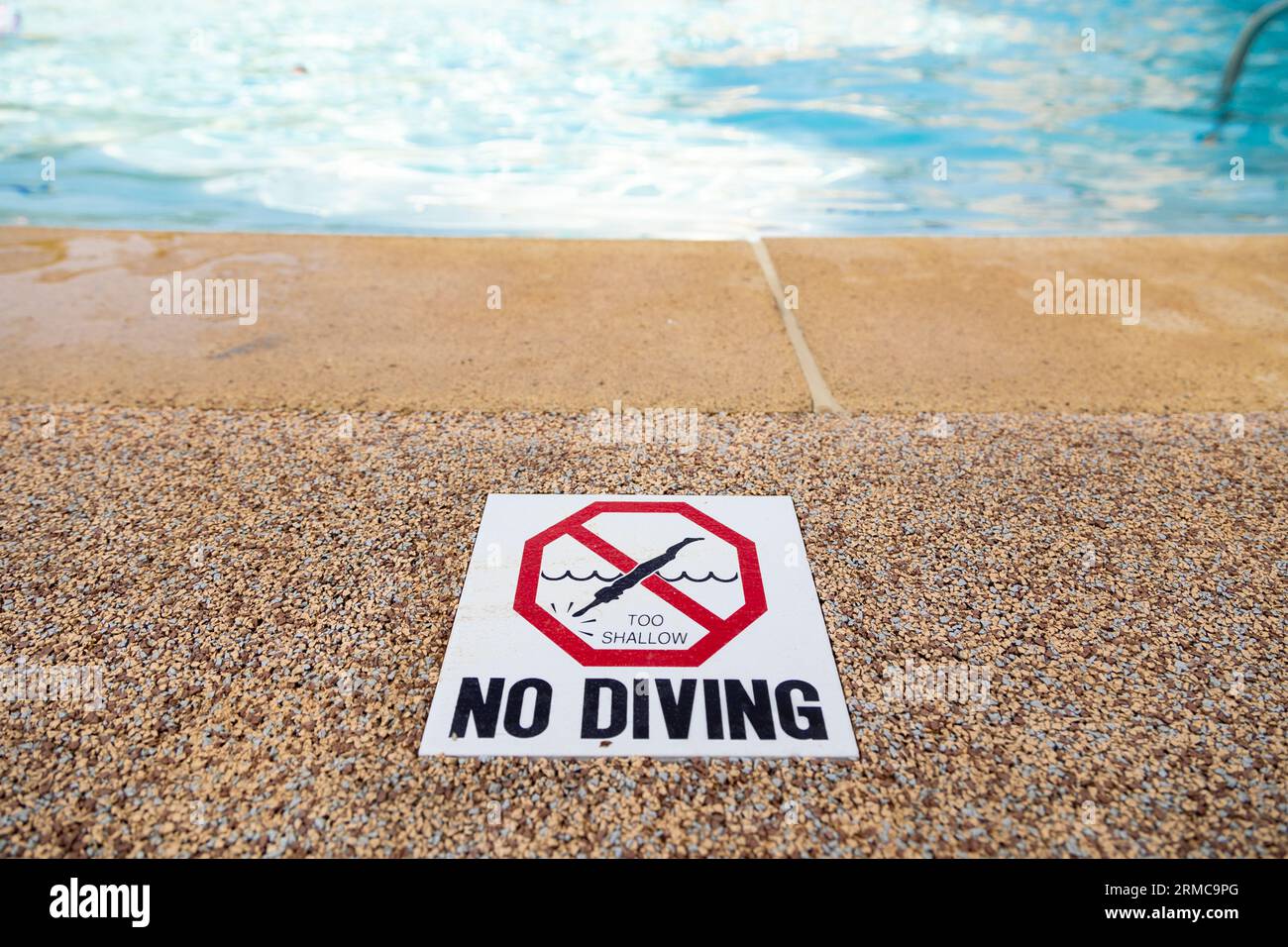 Edge of swimming pool with NO DIVING warning sign Stock Photo - Alamy