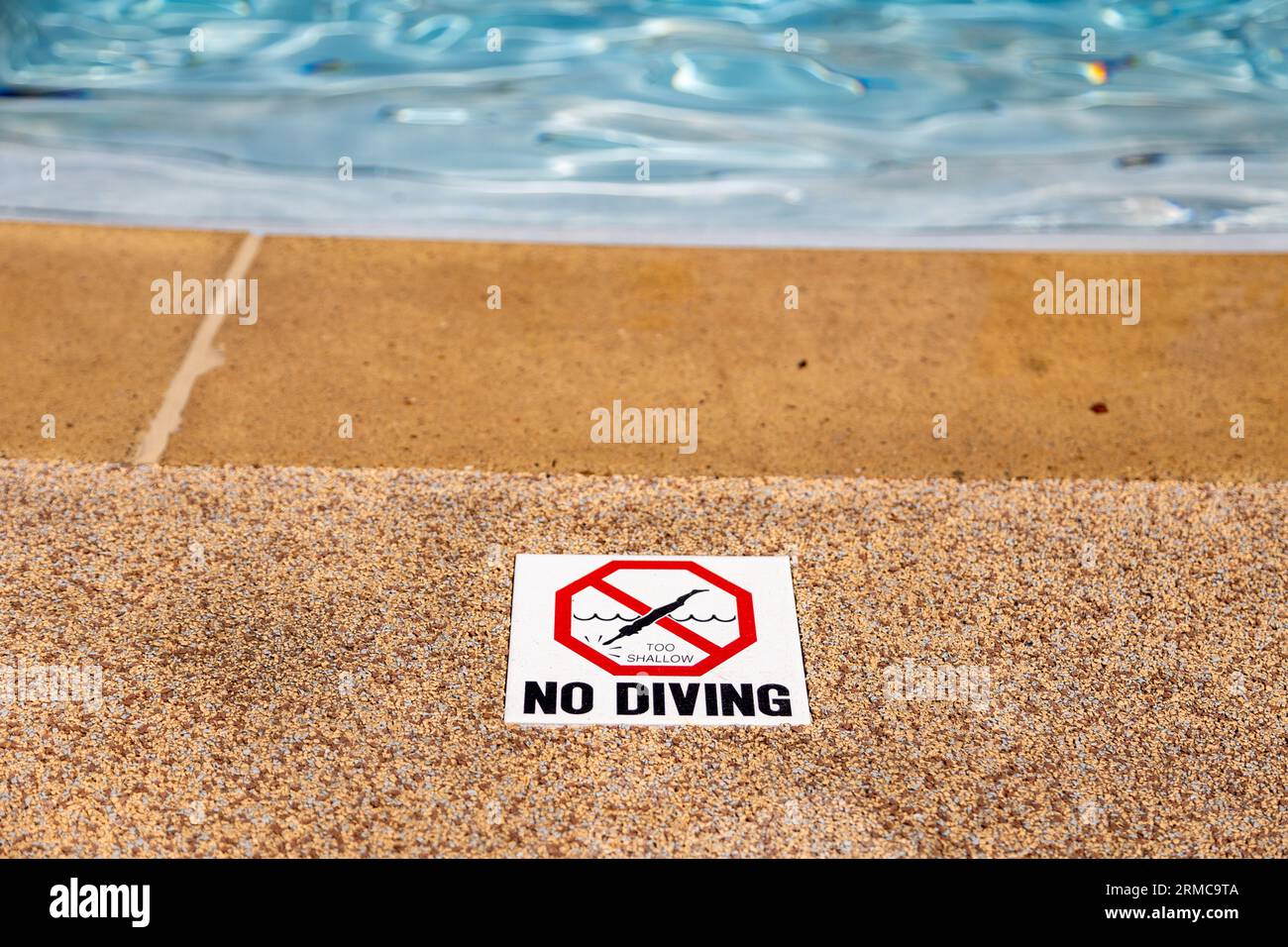 Edge of swimming pool with no diving warning sign Stock Photo - Alamy