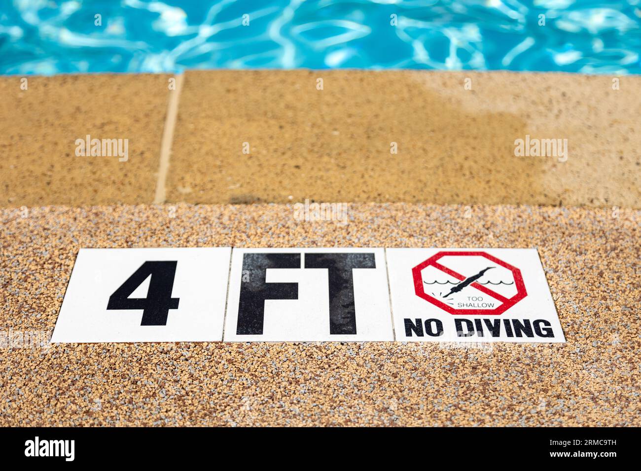 Edge of swimming pool with no diving warning sign and 4 foot depth marker Stock Photo - Alamy