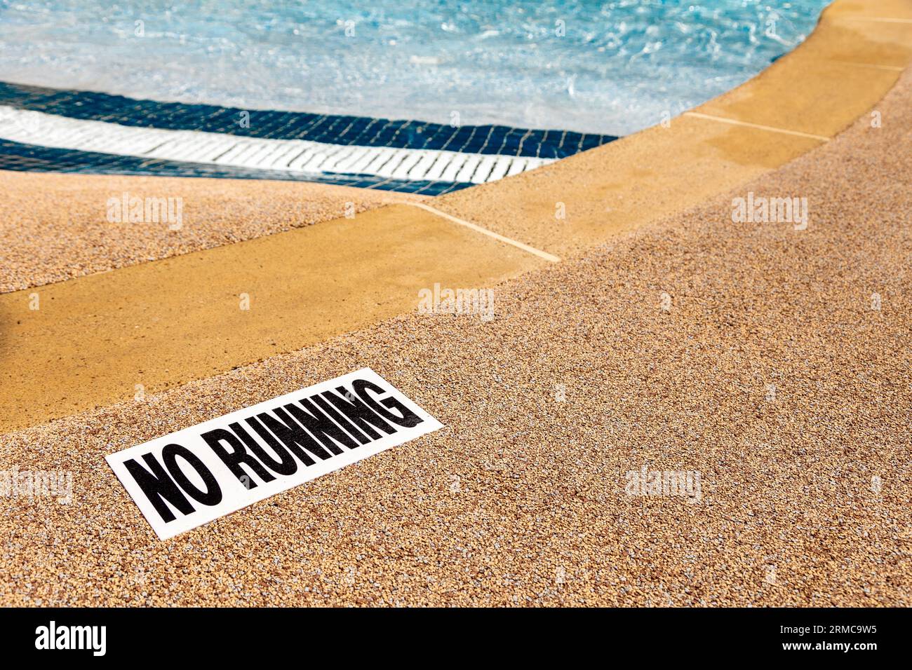 Edge of swimming pool with NO RUNNING warning sign Stock Photo - Alamy
