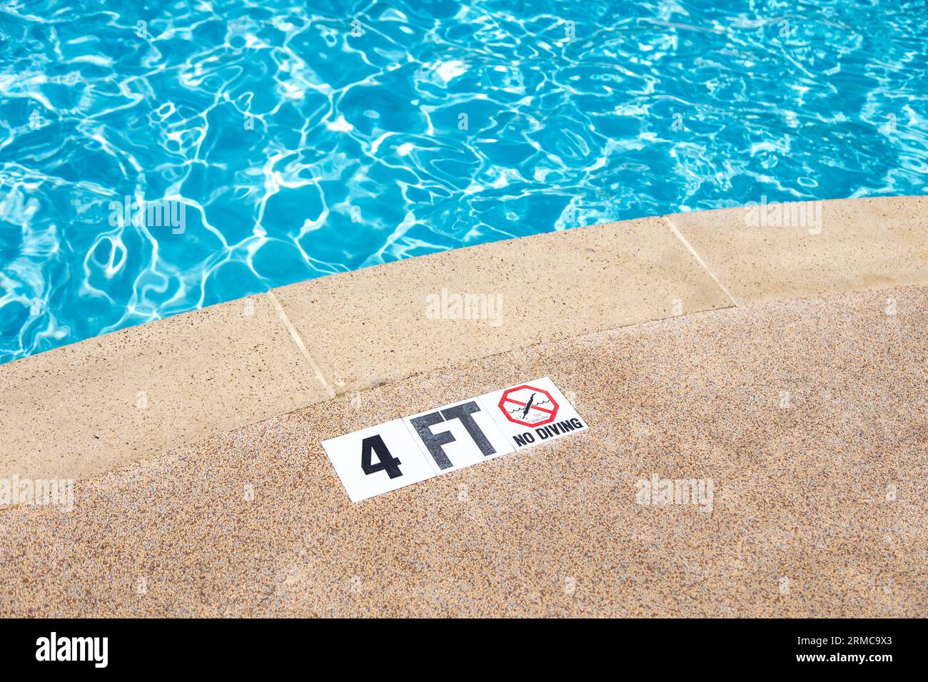 Edge of swimming pool with no diving warning sign and 4 foot depth ...