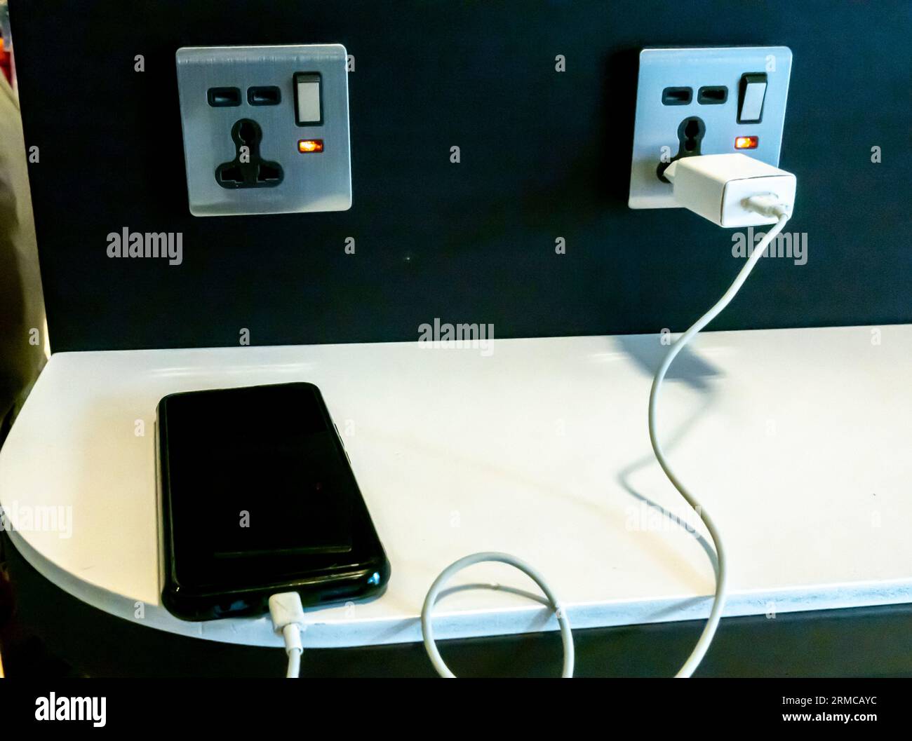 Mobile phones charging station with electric outlet. Cell phone ...