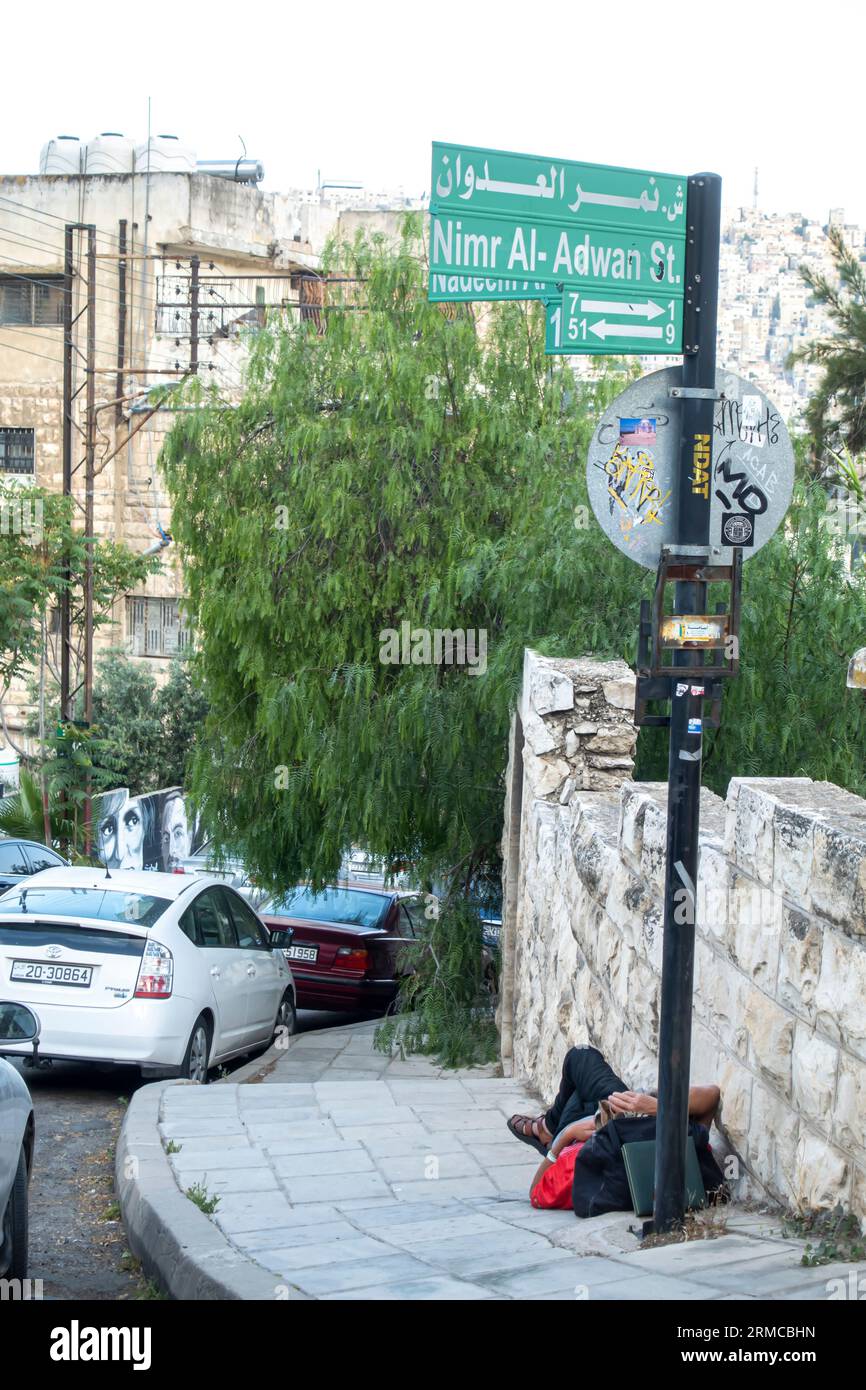 Homeless sleeping in the street under city direction signs in central ...