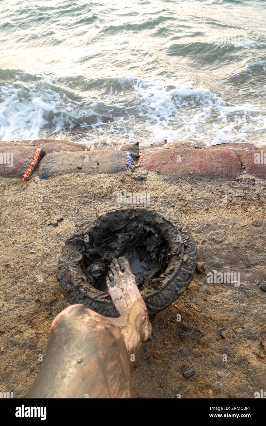 Man's foot in mud bowl, man's leg covered with mud. Bowl with mud for ...