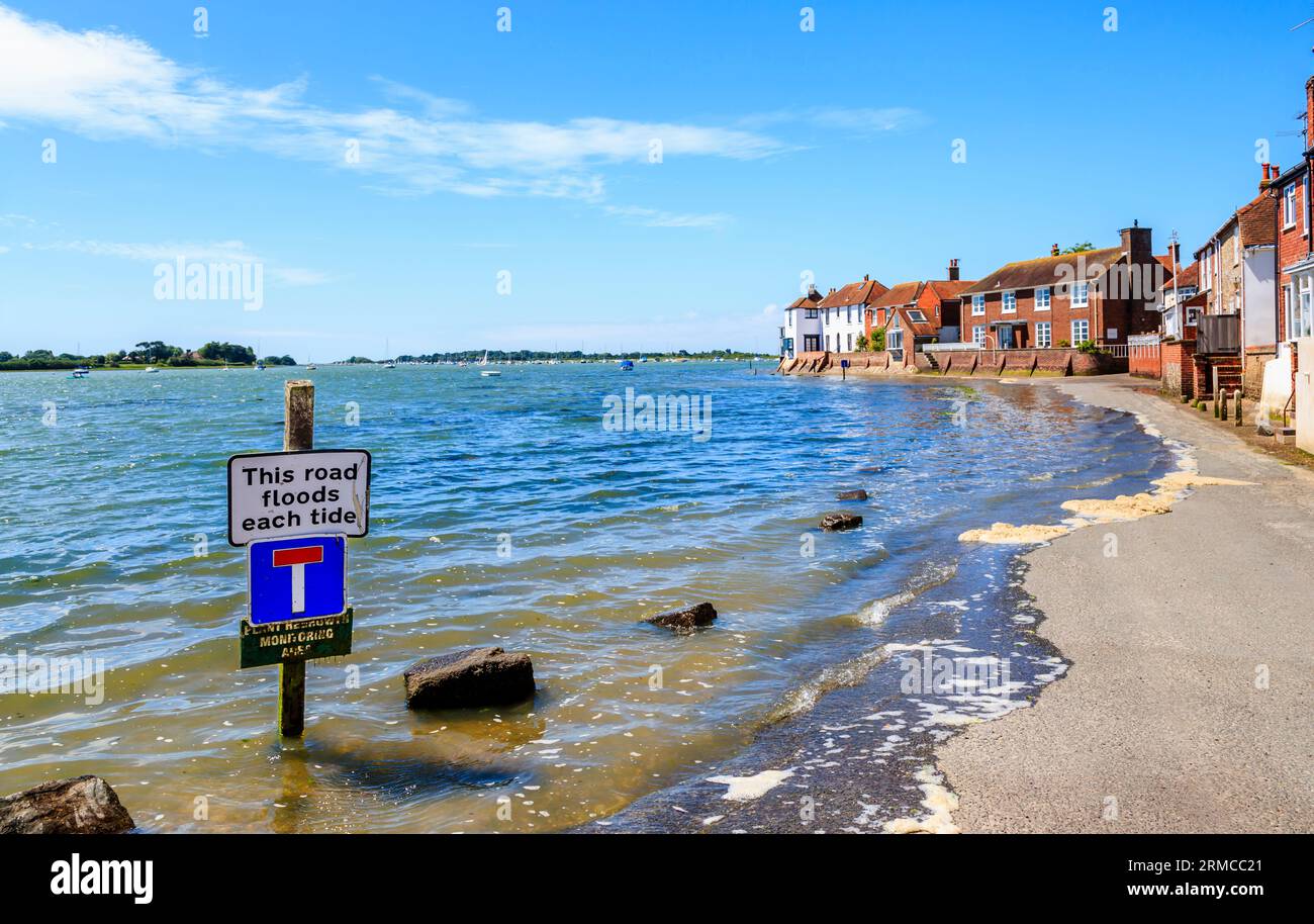 Rising tide flooding the seafront access road, Bosham, a south coast ...