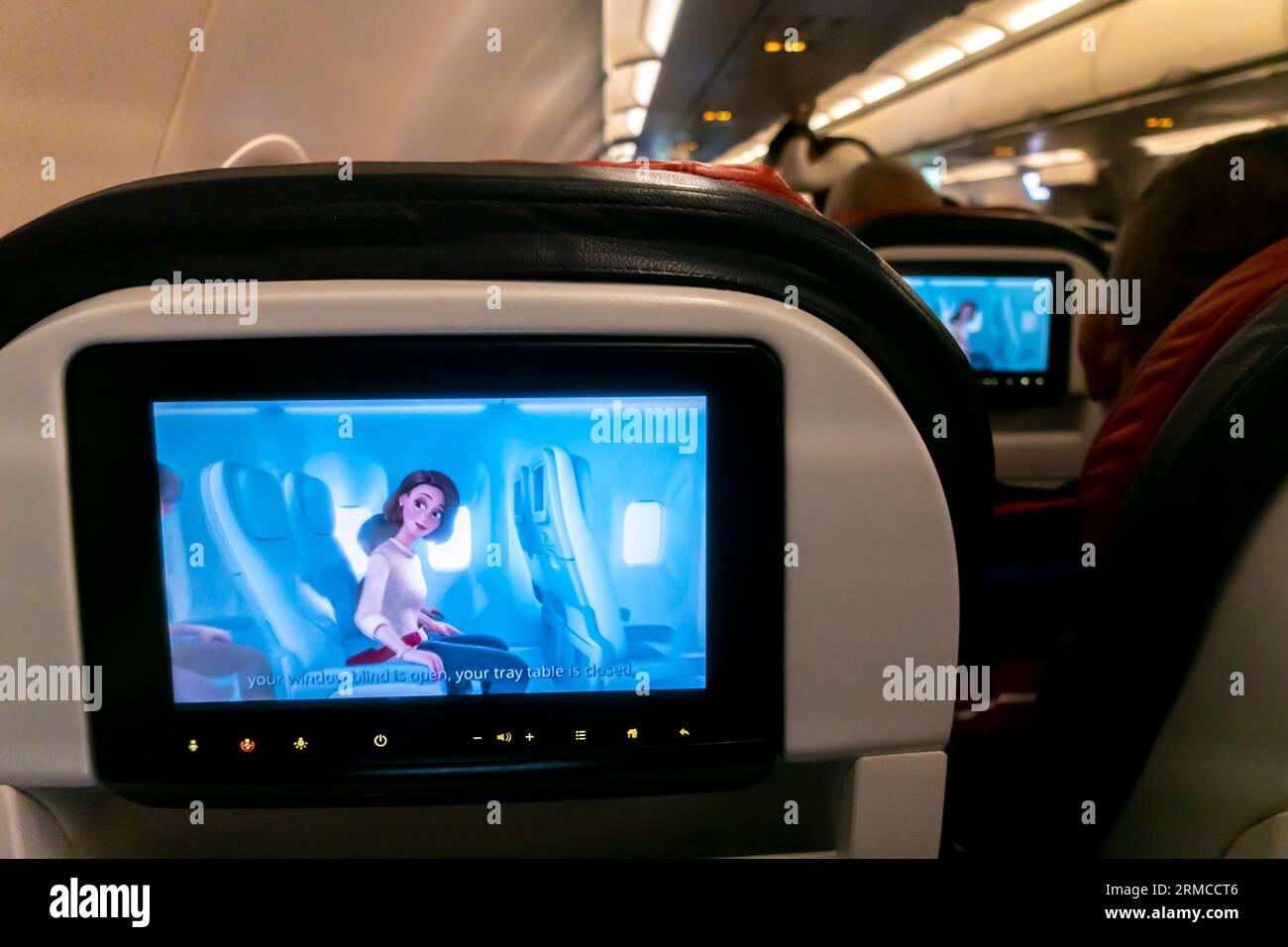 Personal television, PTV in front of an airplane seat showing instructions on fasting seat belts ...