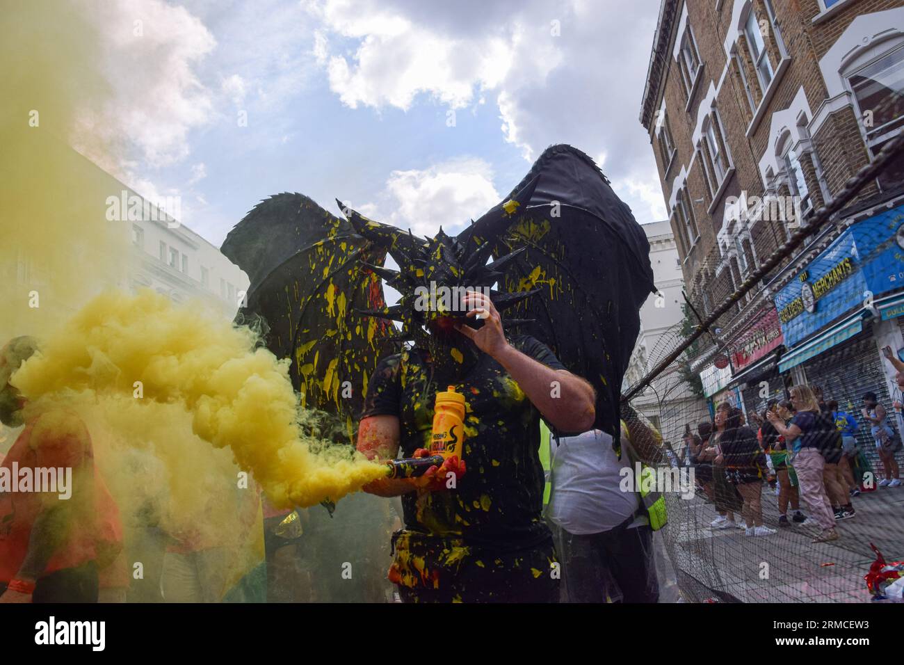 London, UK. 27th August 2023. A participant sets off a smoke flare as ...