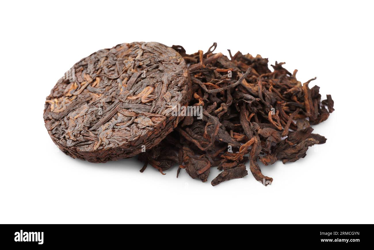 Disc shaped traditional Chinese pu-erh tea and leaves isolated on white ...