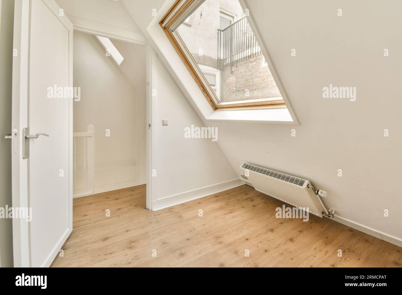 an attic room with wood flooring and skylights on the side of the ...