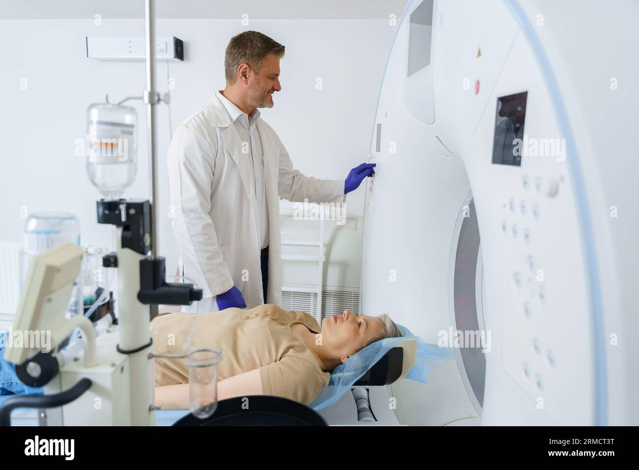 Doctor radiologist pushing button on panel to start mri scan procedure ...