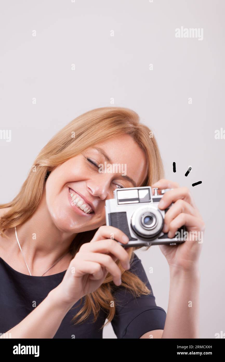 Close-up portrait of a woman capturing moments with an analog camera ...