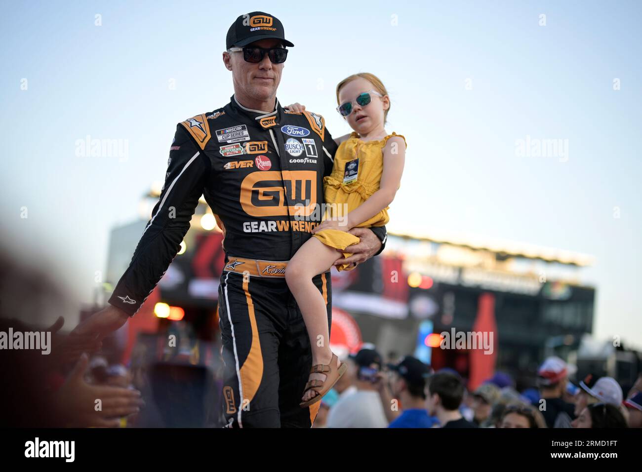 Kevin Harvick carries his daughter Piper while slapping hands with ...