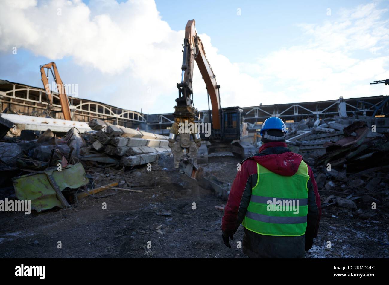Excavator destroyer removes debris under worker control Stock Photo - Alamy
