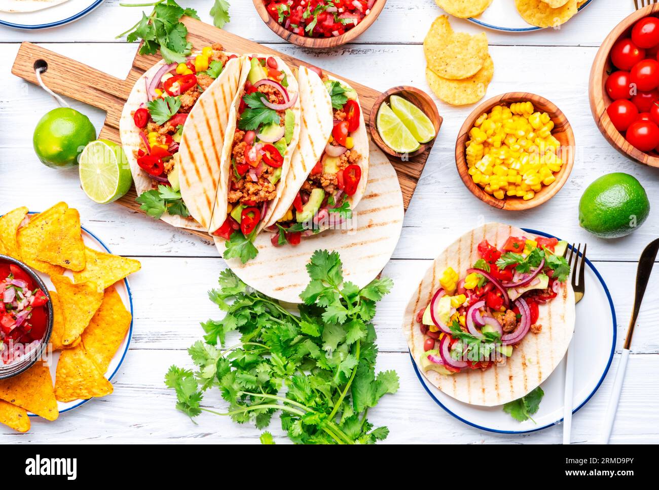 Taco party. Served table with tortillas, nachos, sauces, appetizers and ...