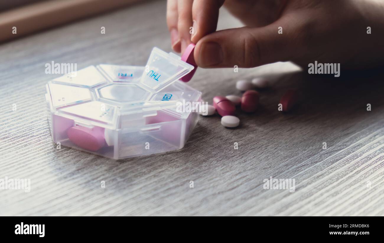 Woman sorting pills Organizer weekly shots Closeup of medical pill box ...