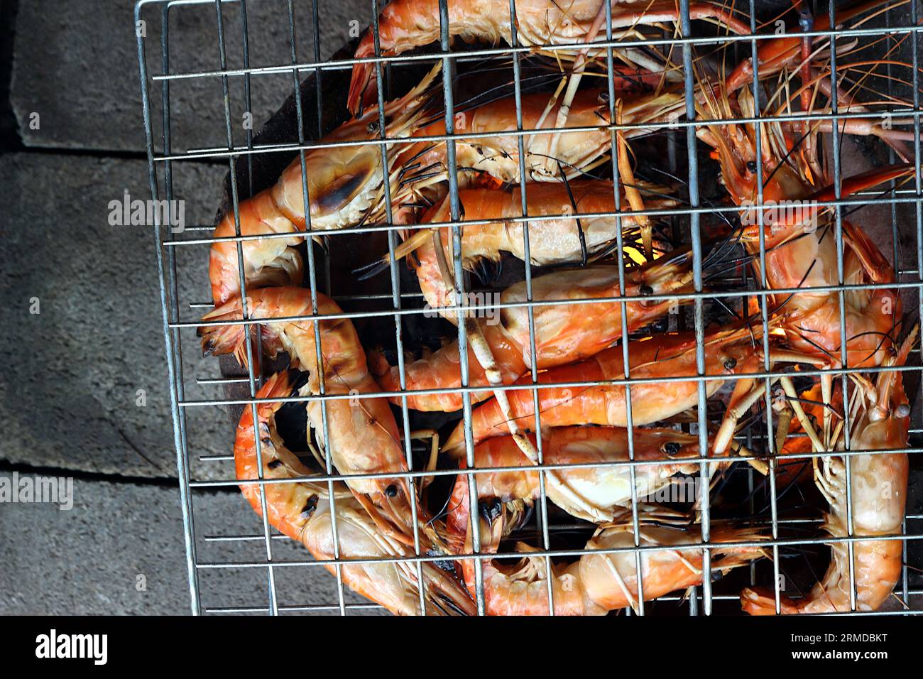 Many giant freshwater prawns are being grilled in the grill over the ...