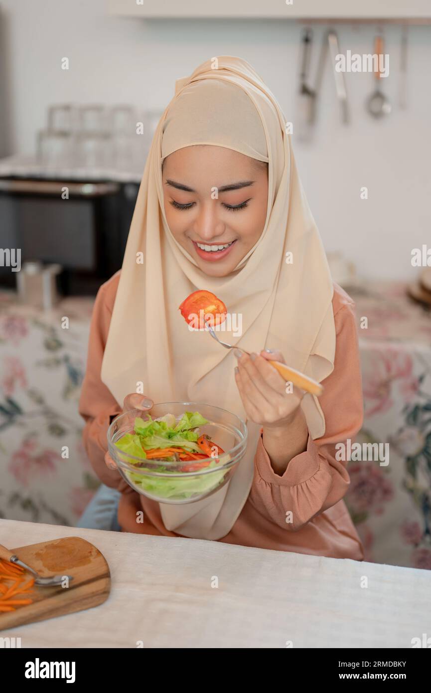Woman eating table head scarf hi-res stock photography and images - Alamy