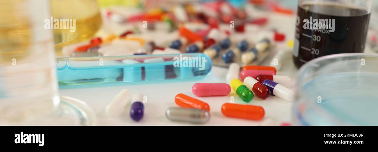 Colored capsules and test tubes on the table in laboratory Stock Photo ...