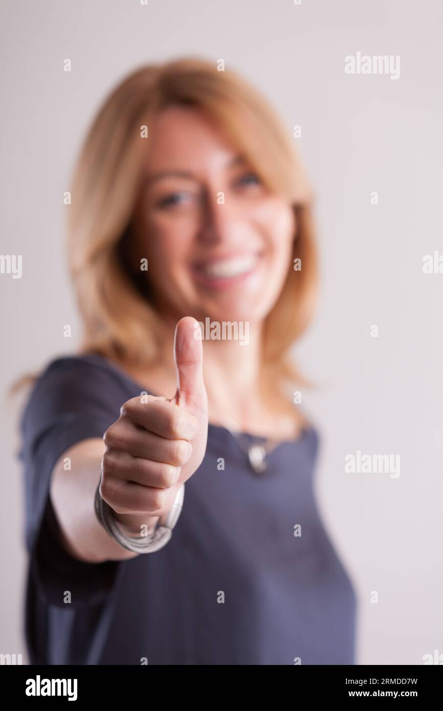 Blurred in the background, a jubilant adult woman innovatively gives a ...