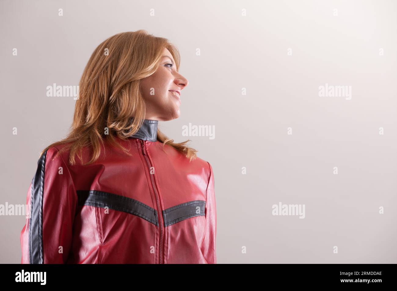 woman in a striking red and black motorcycle jacket leans back ...
