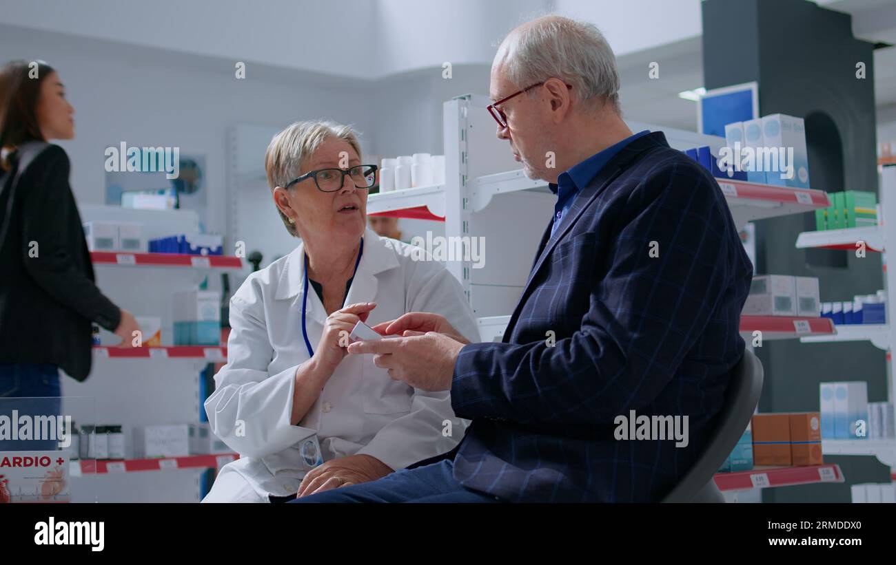 Elderly pharmacist in drugstore with senior patient after finishing ...