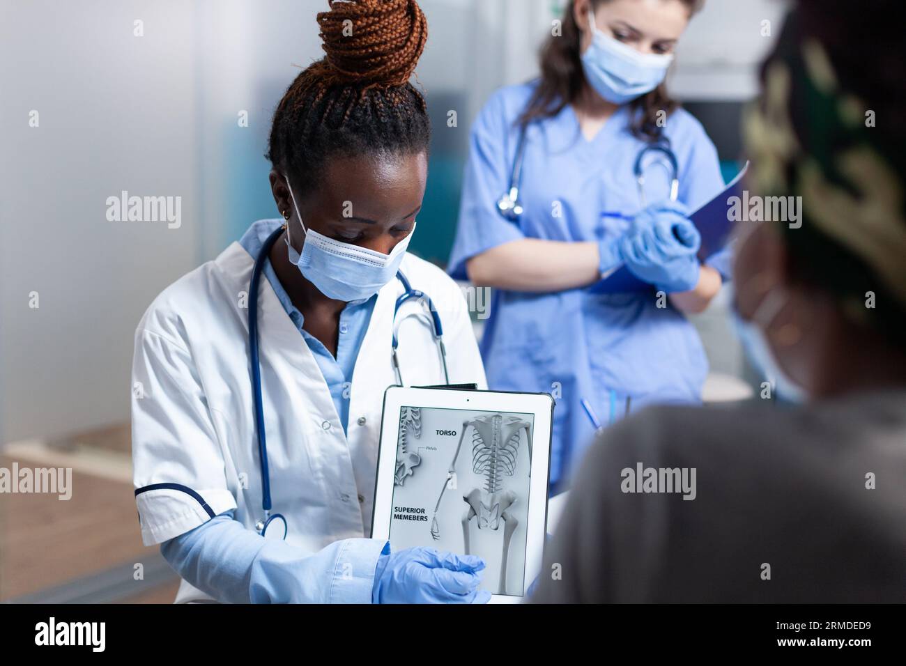Bone doctor explaining clinical information on tablet to patient during ...