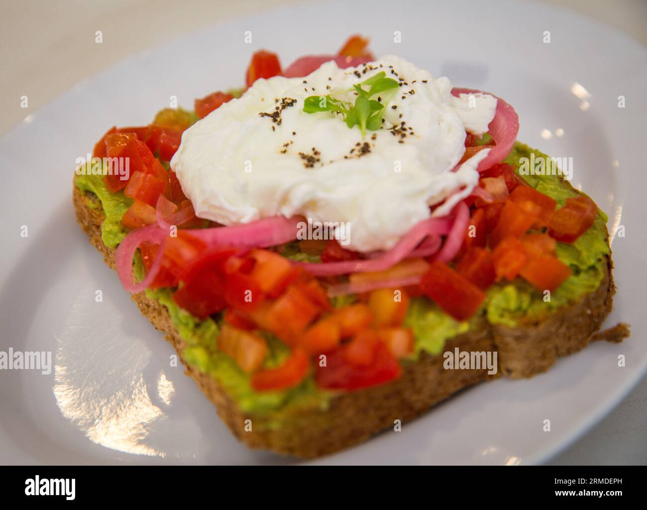 Avocado toast with eggs, tomatoes and pickled onions Stock Photo - Alamy