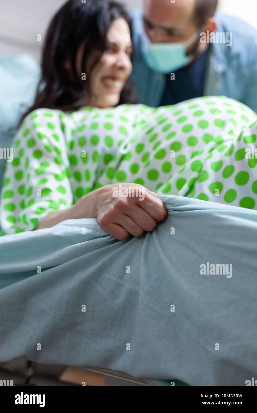 Pregnant woman pushing hard to delivery baby in hospital ward, having ...