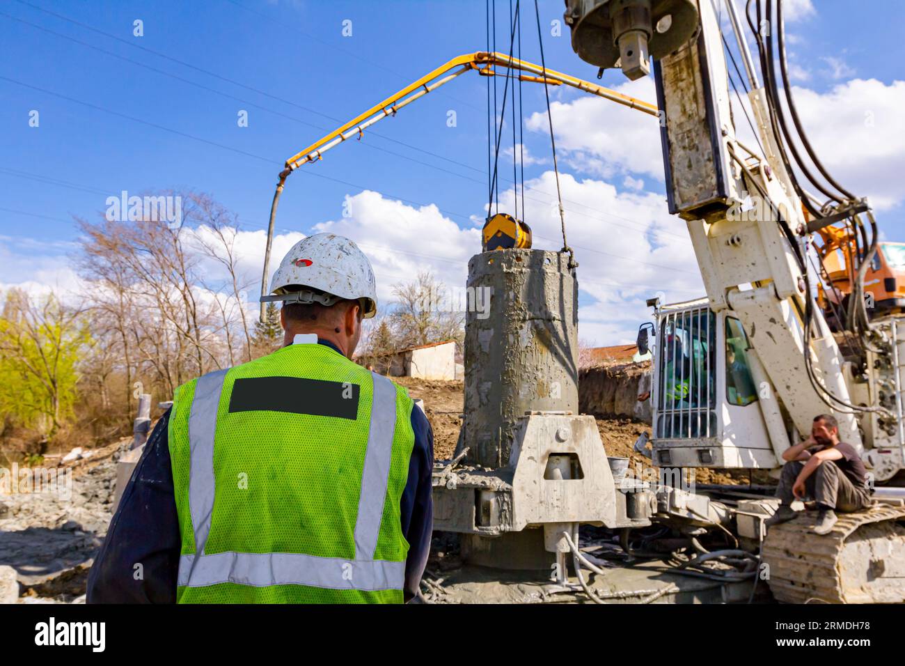View from behind on construction worker with safety vest and white ...
