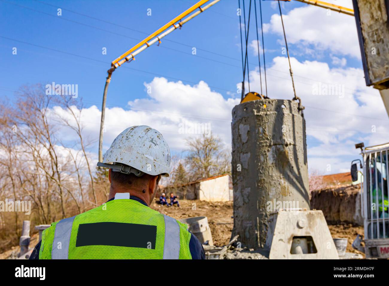 View from behind on construction worker with safety vest and white ...