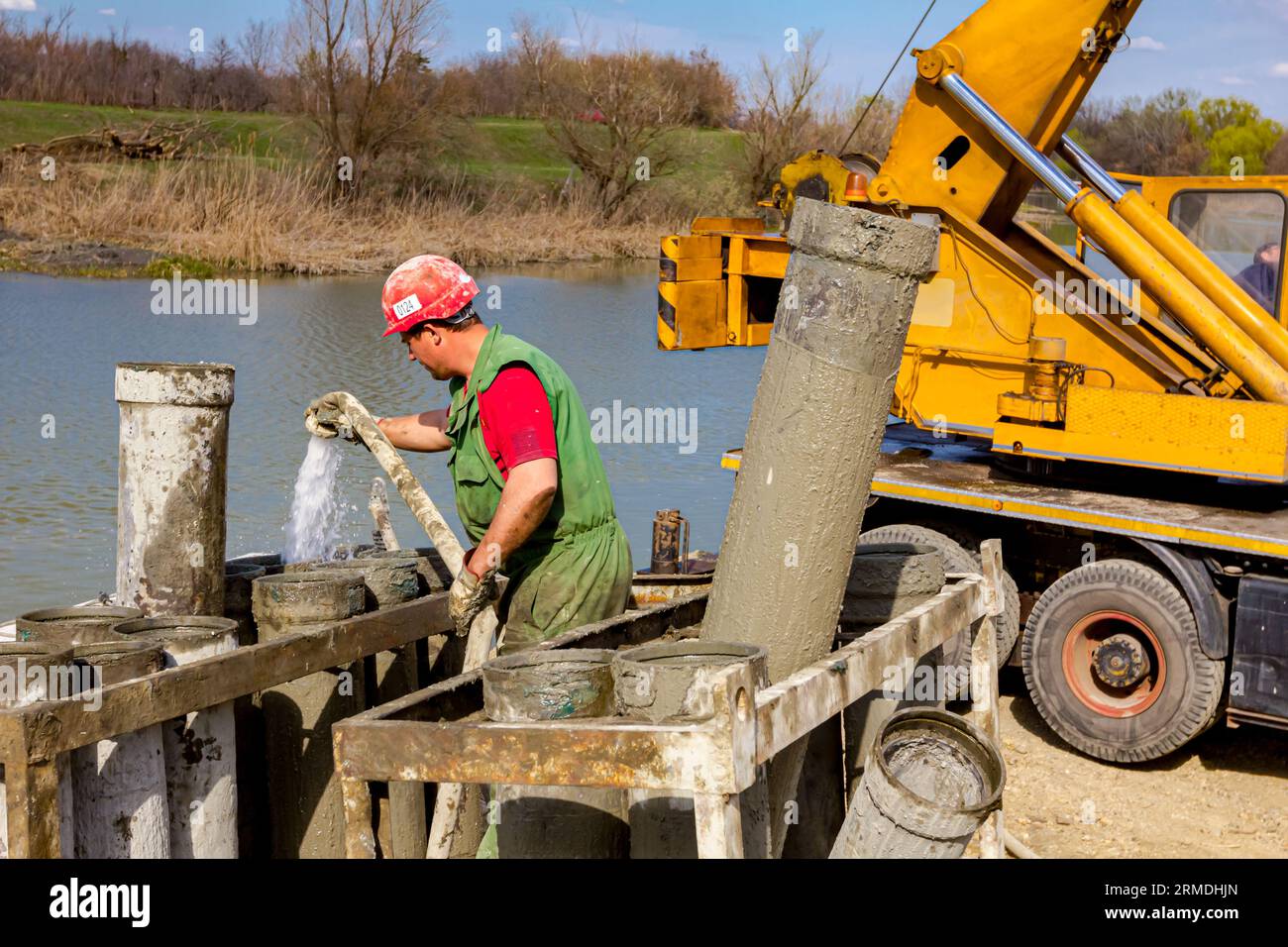 Rigger, worker with safety helmet is using hose to wash with water ...