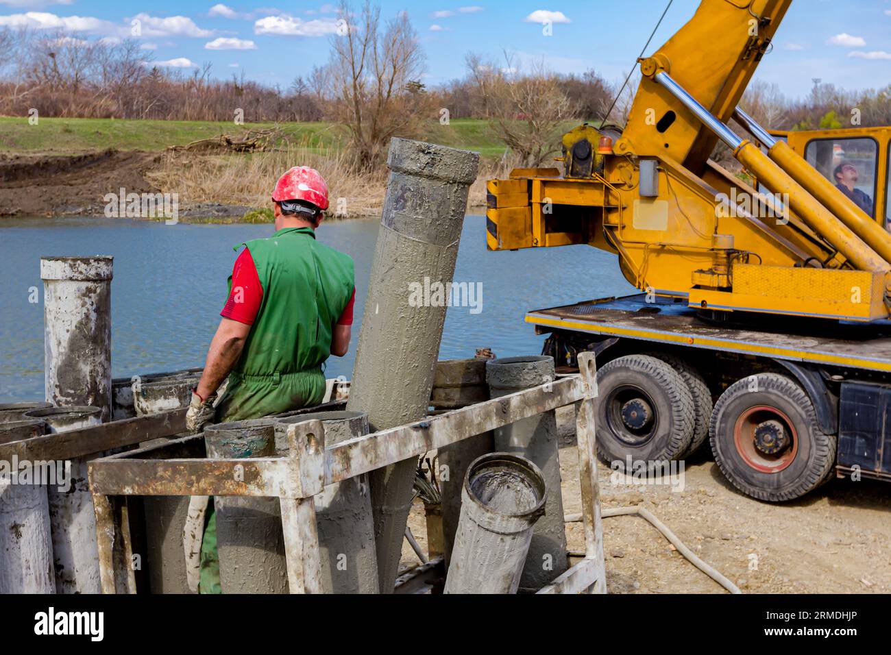 Rigger, worker with safety helmet is using hose to wash with water ...