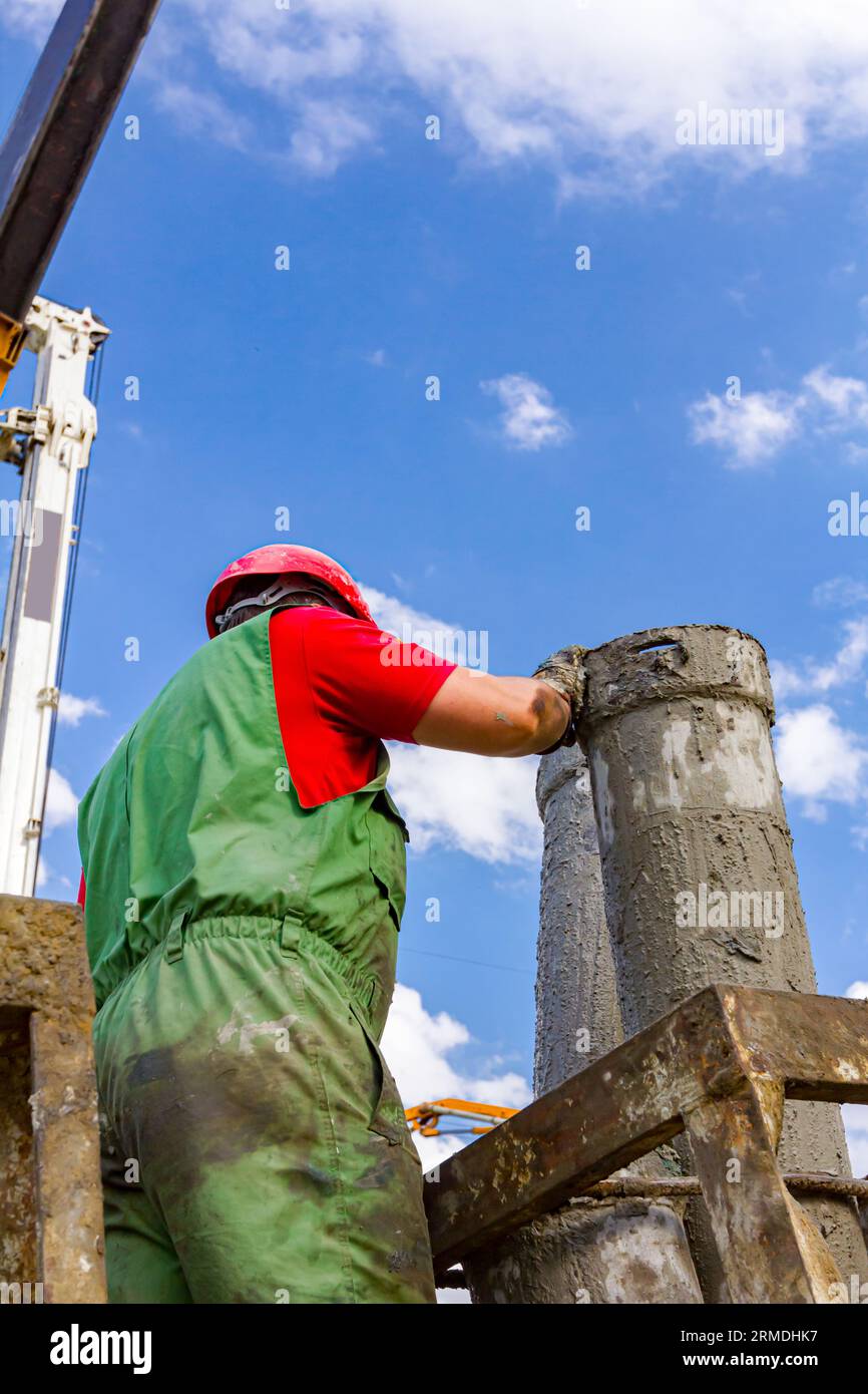 Rigger, worker with safety helmet disassembles pump canal for vertical ...