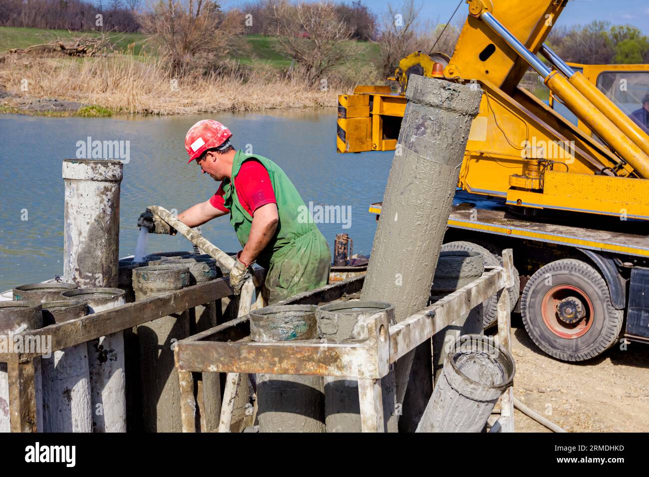Rigger, worker with safety helmet is using hose to wash with water ...