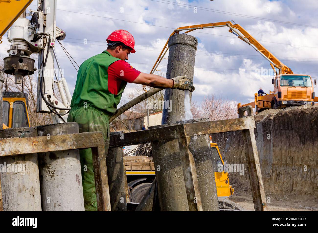 Rigger, worker with safety helmet is using hose to wash with water ...
