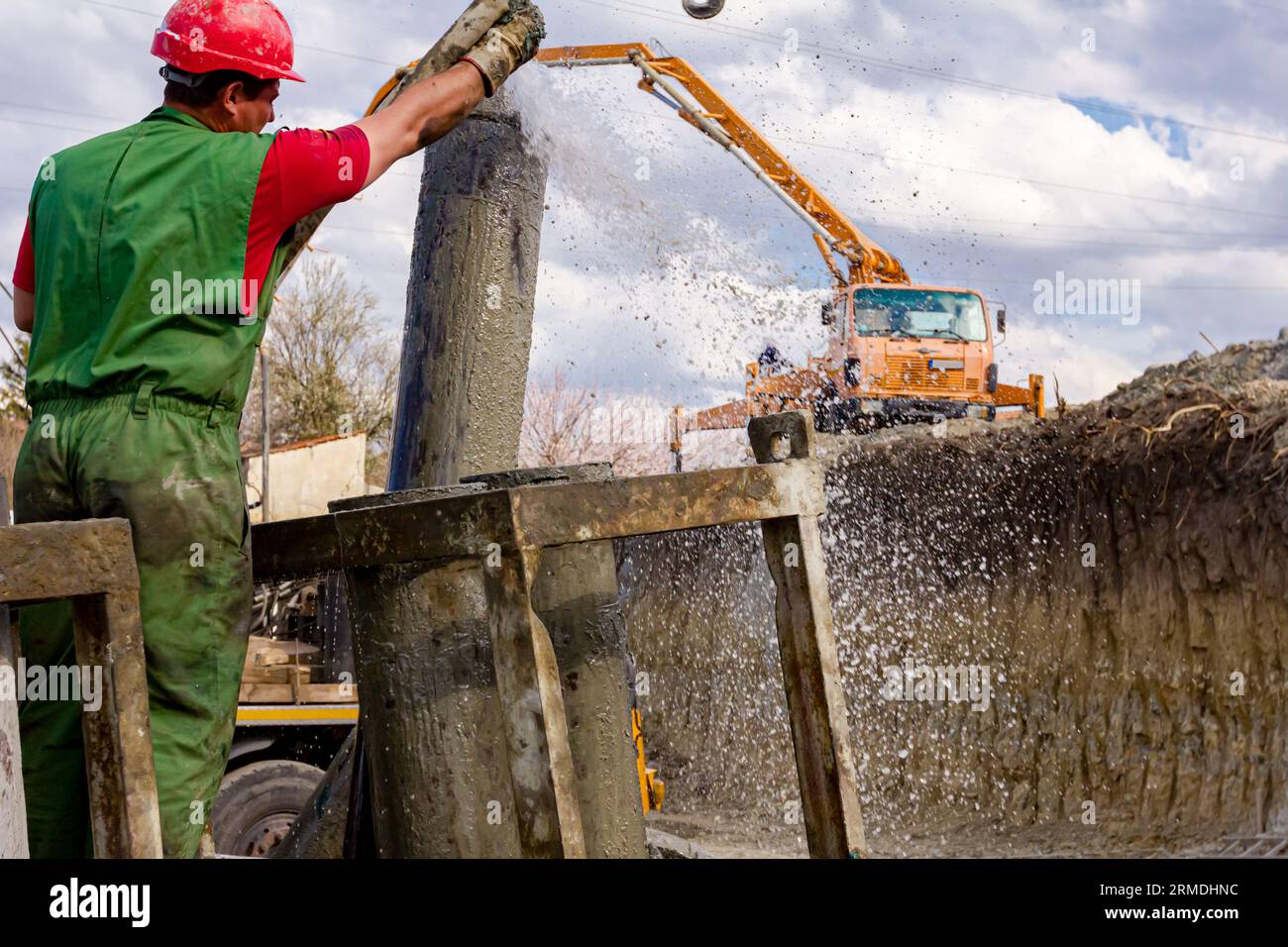 Rigger, worker with safety helmet is using hose to wash with water ...