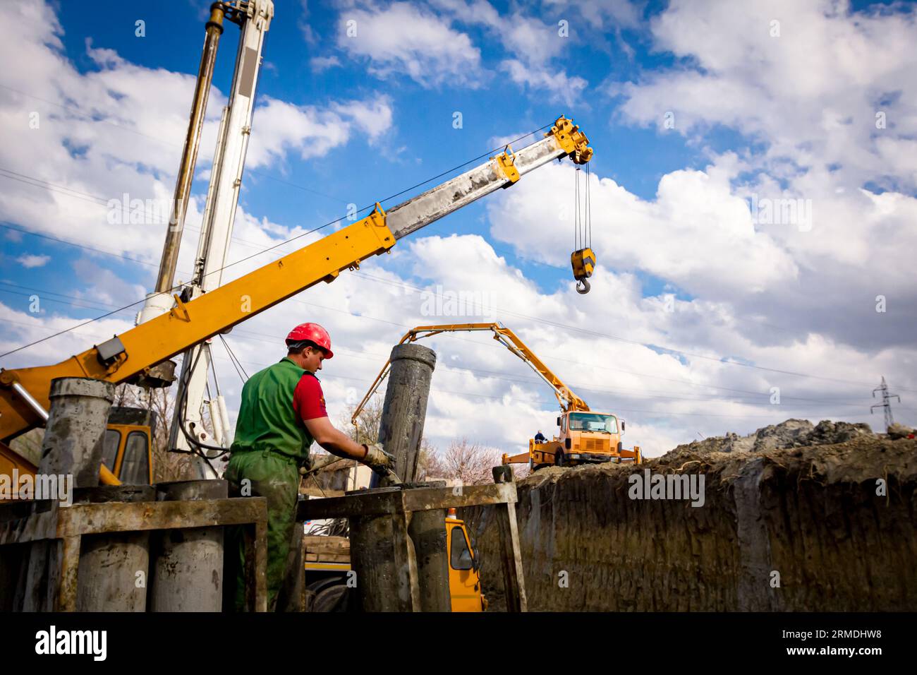 Rigger, worker with safety helmet is using hose to wash with water ...