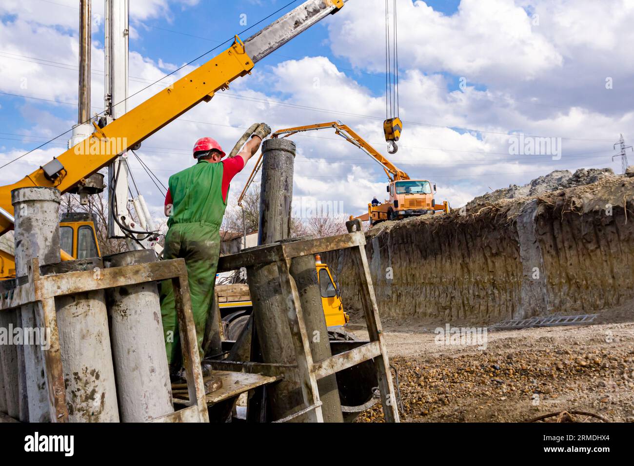 Rigger, worker with safety helmet is using hose to wash with water ...