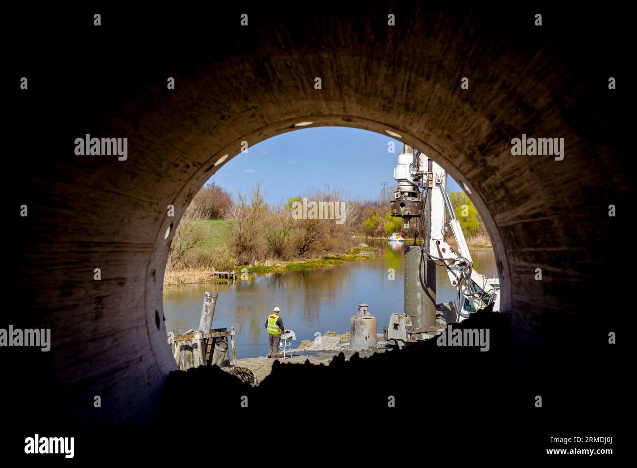 Perspective view trough pipe, from behind on worker with safety vest ...