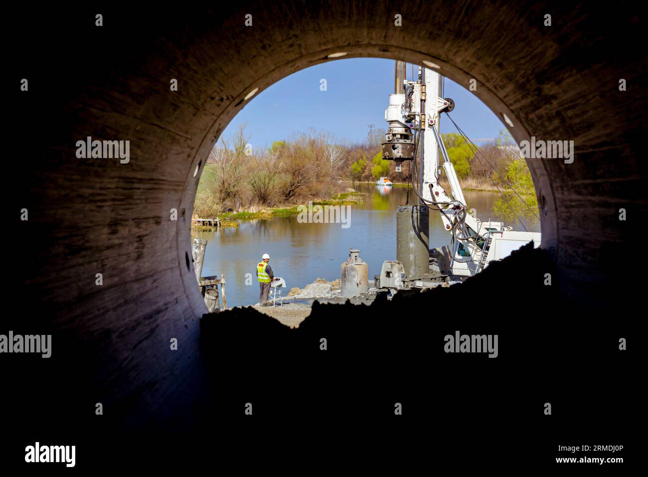 Perspective view trough pipe, from behind on worker with safety vest ...
