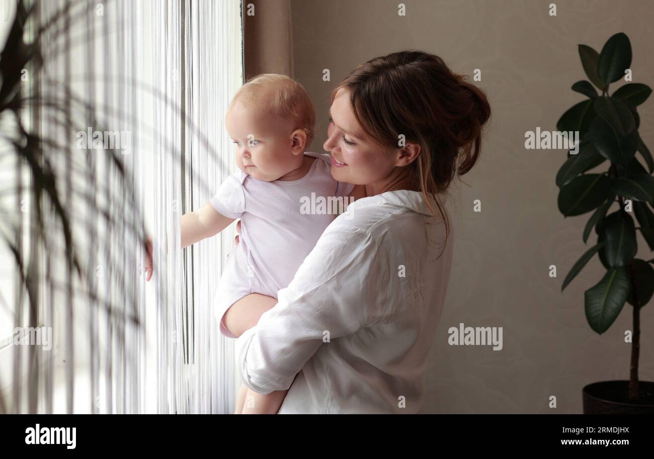 Loving tender young mum holding adorable cute baby girl daughter ...