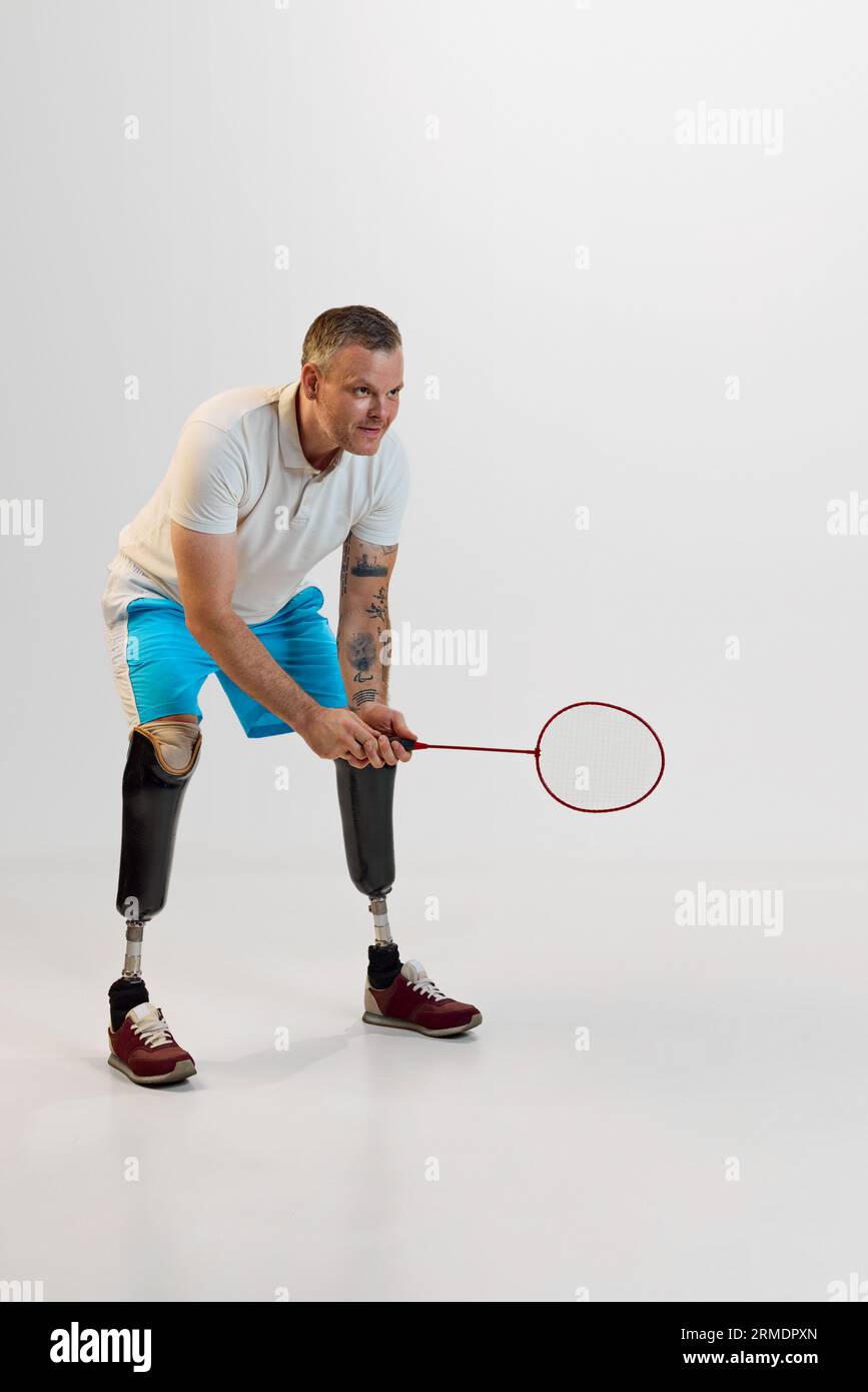 Full length of confident man with prosthesis play badminton, ready to ...