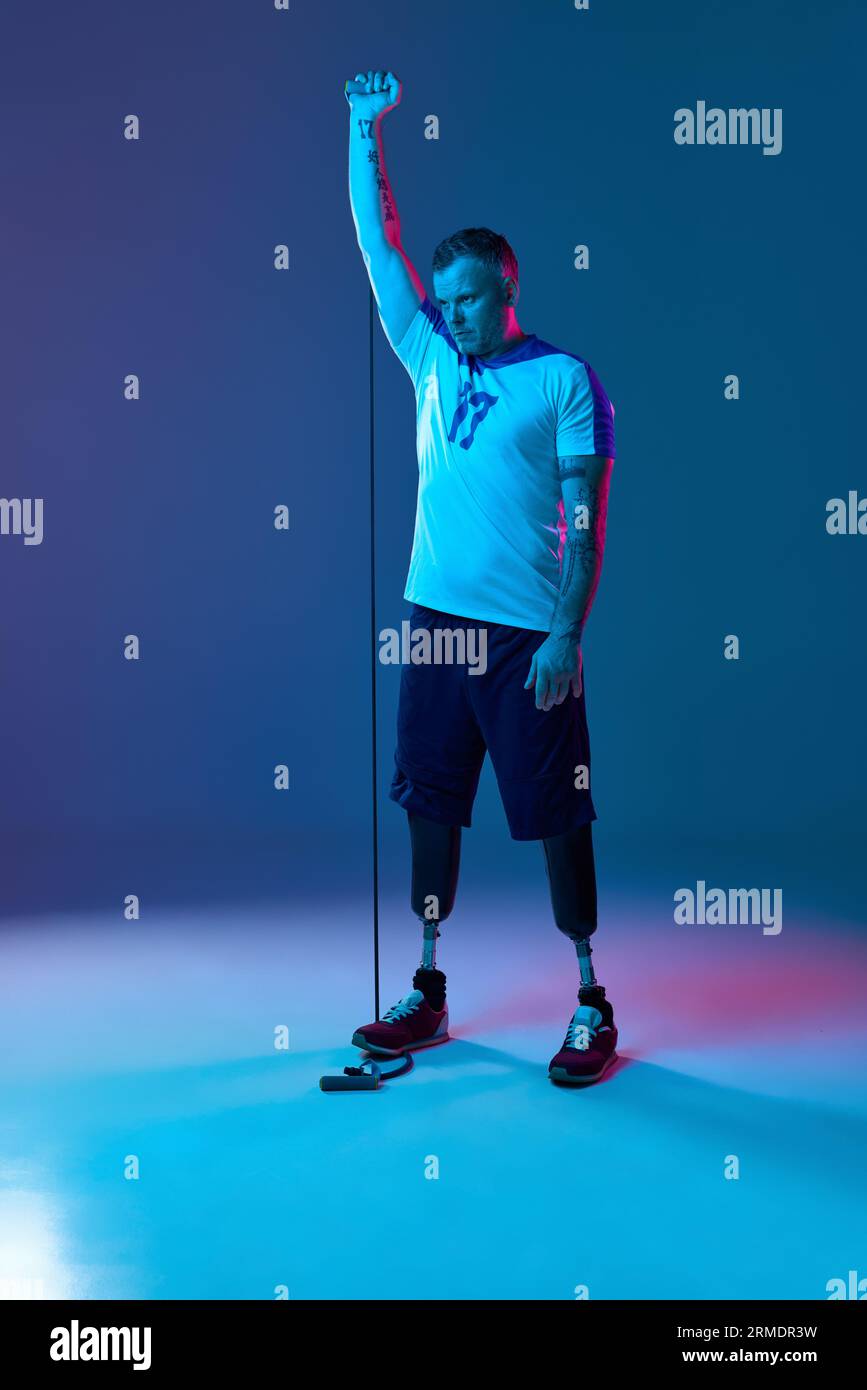 Confident man in sport uniform prosthetic legs doing exercises ...