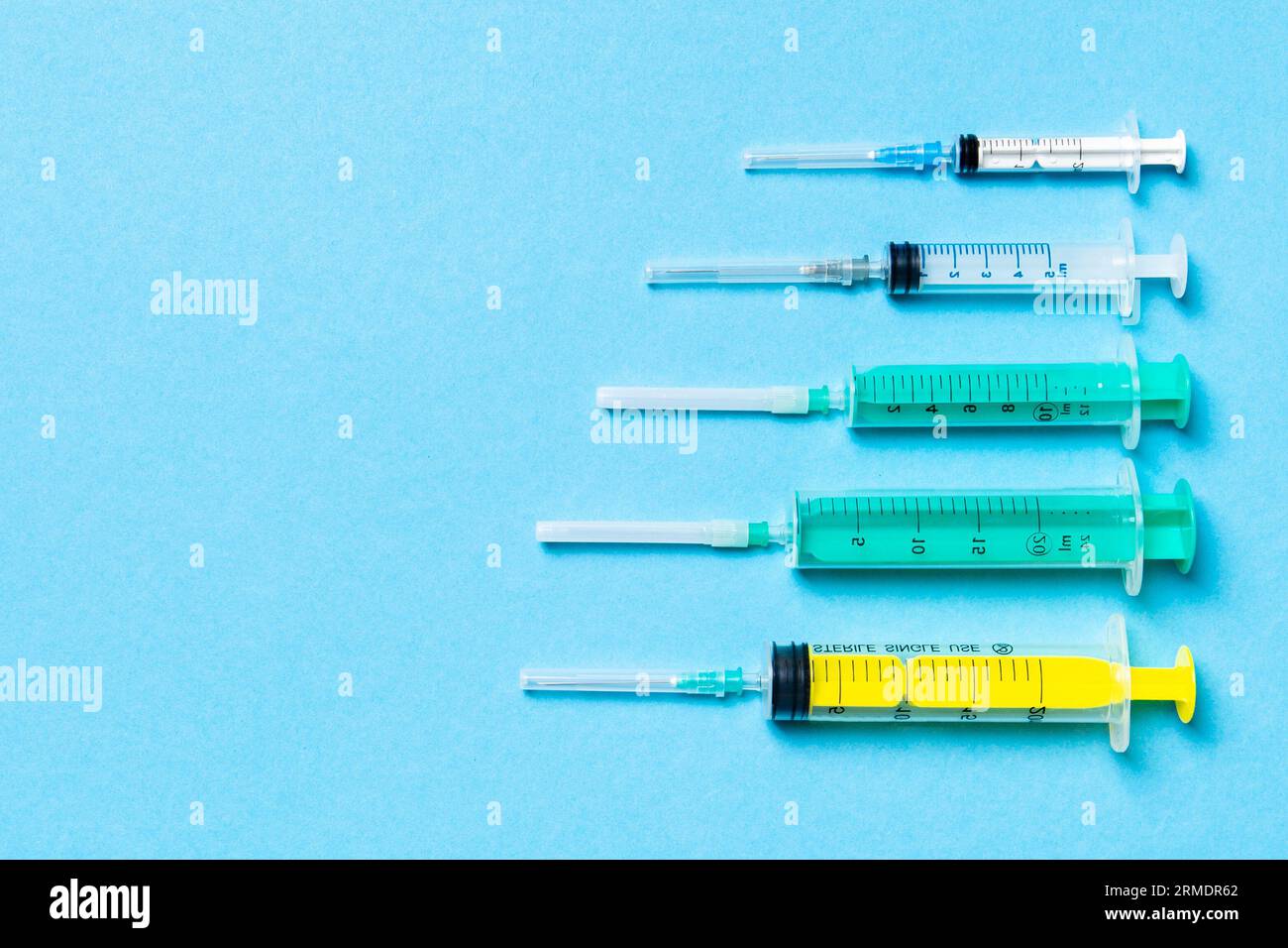 Top view of medical syringes with needles at blue background with copy ...