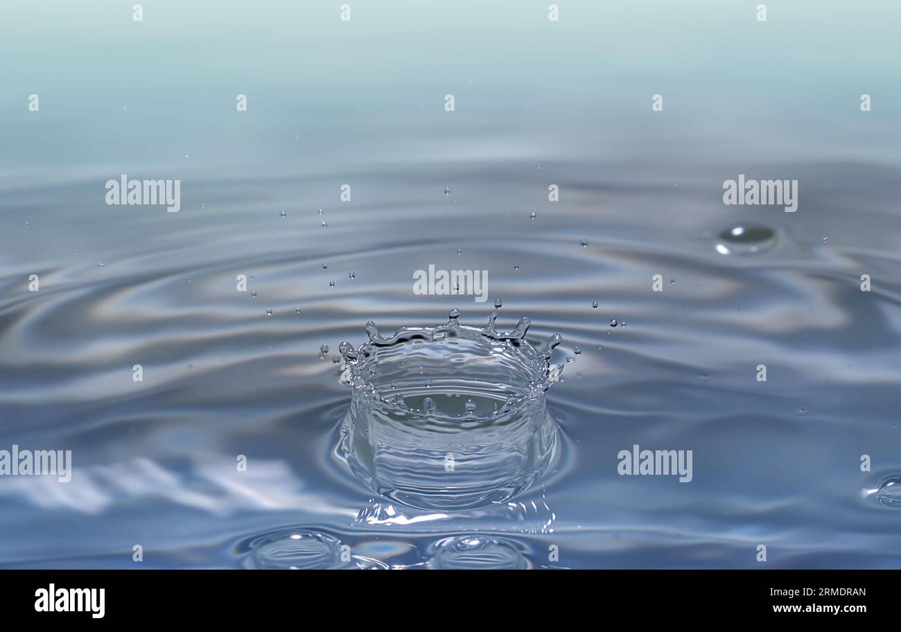 Clear aqua water droplet splashing in concentric circles, capturing ...