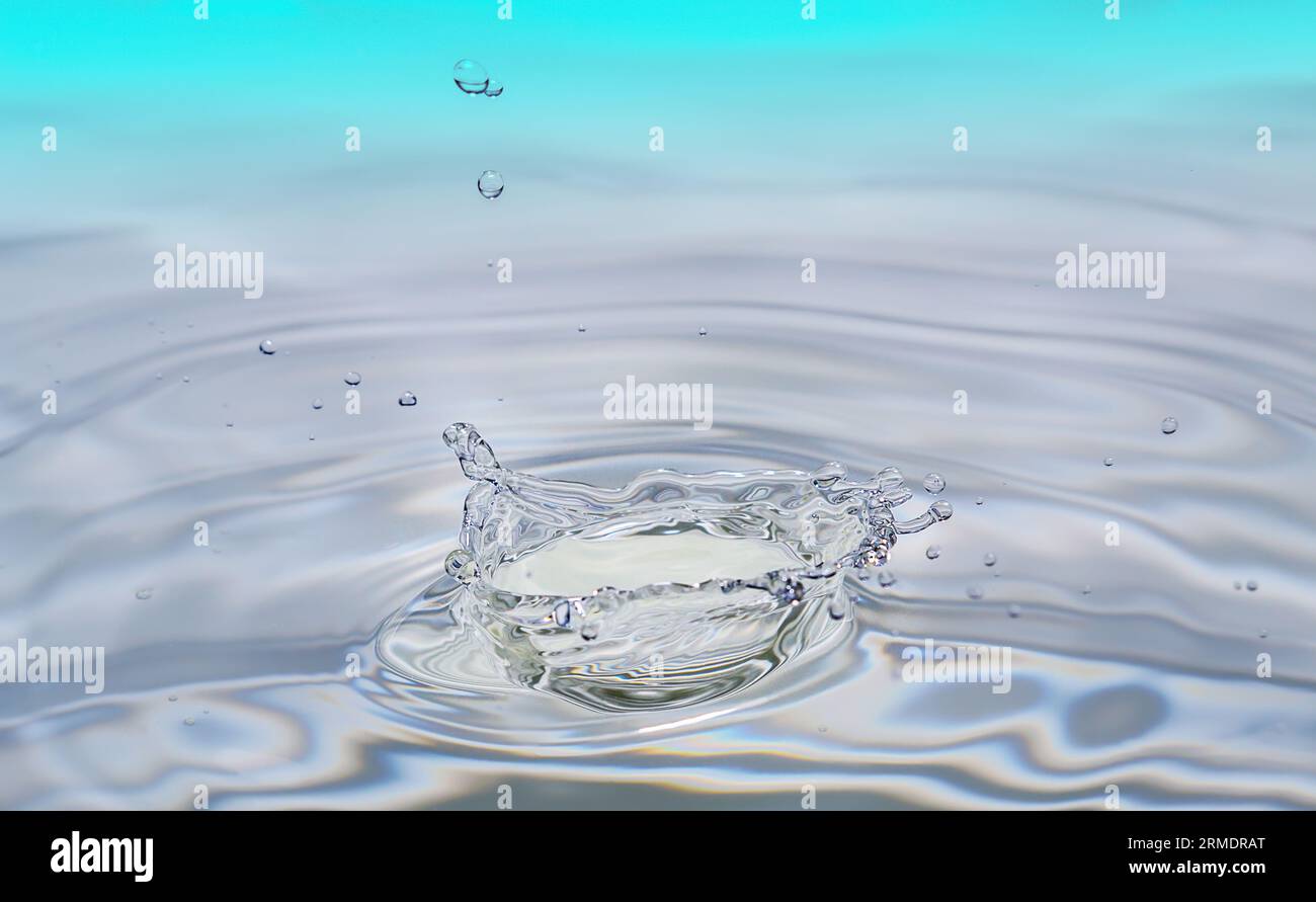 Clear aqua water droplet splashing in concentric circles, capturing ...