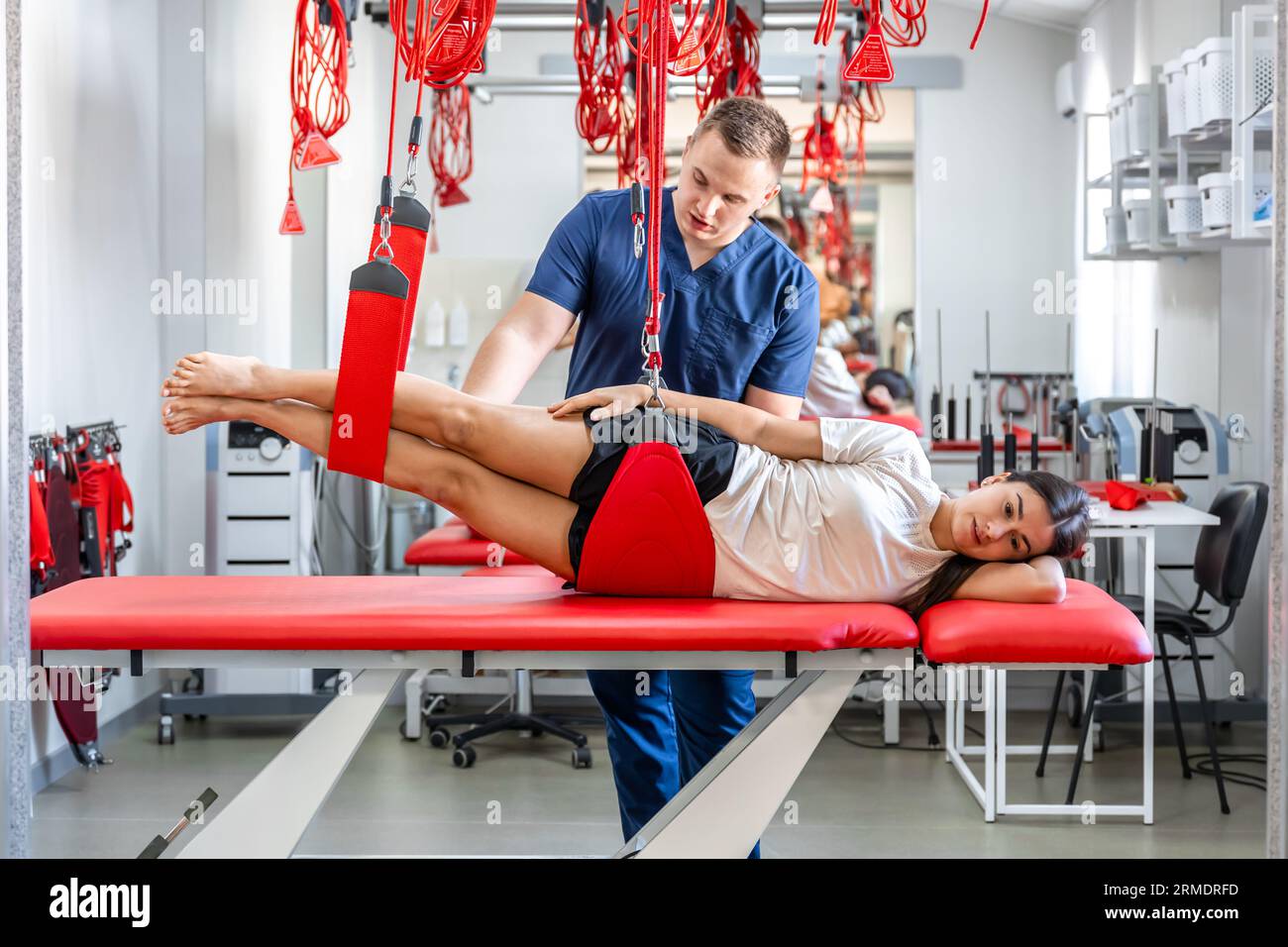 Female patient hanging on suspensions at rehabilitation center Stock ...
