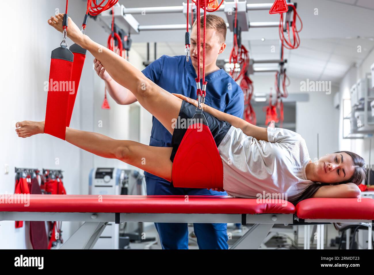 Female patient hanging on suspensions at rehabilitation center Stock ...