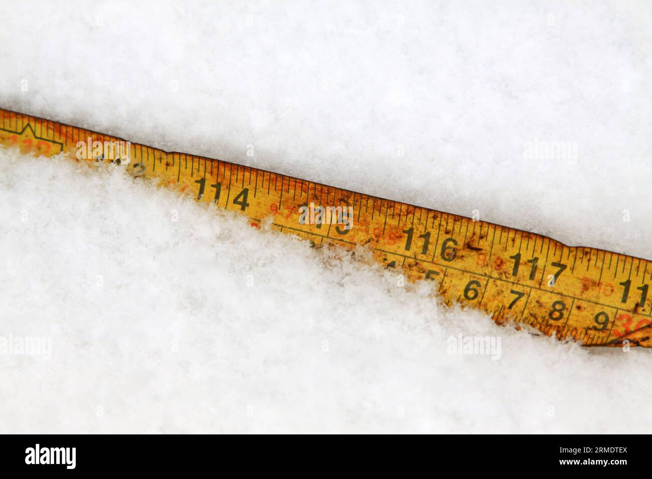 yellow steel tape in the snow, abandoned object Stock Photo - Alamy